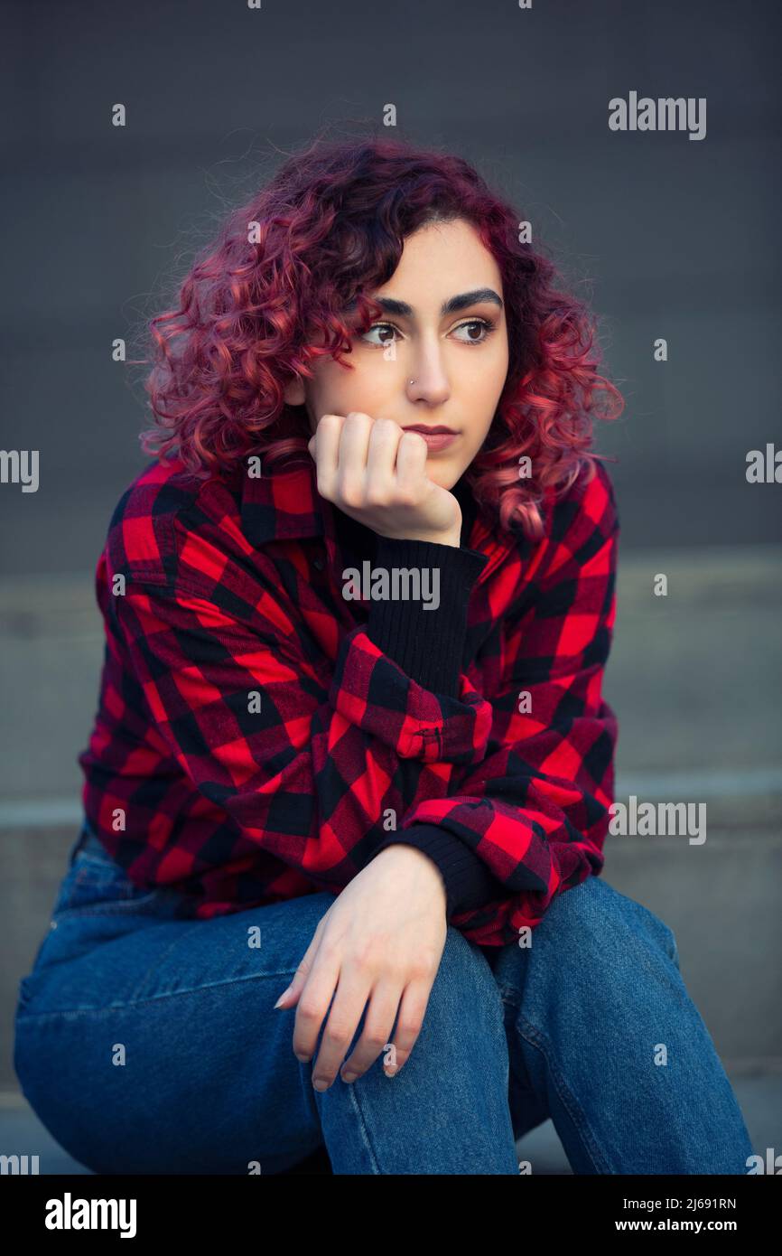 Woman leaning on hand looking away Stock Photo - Alamy