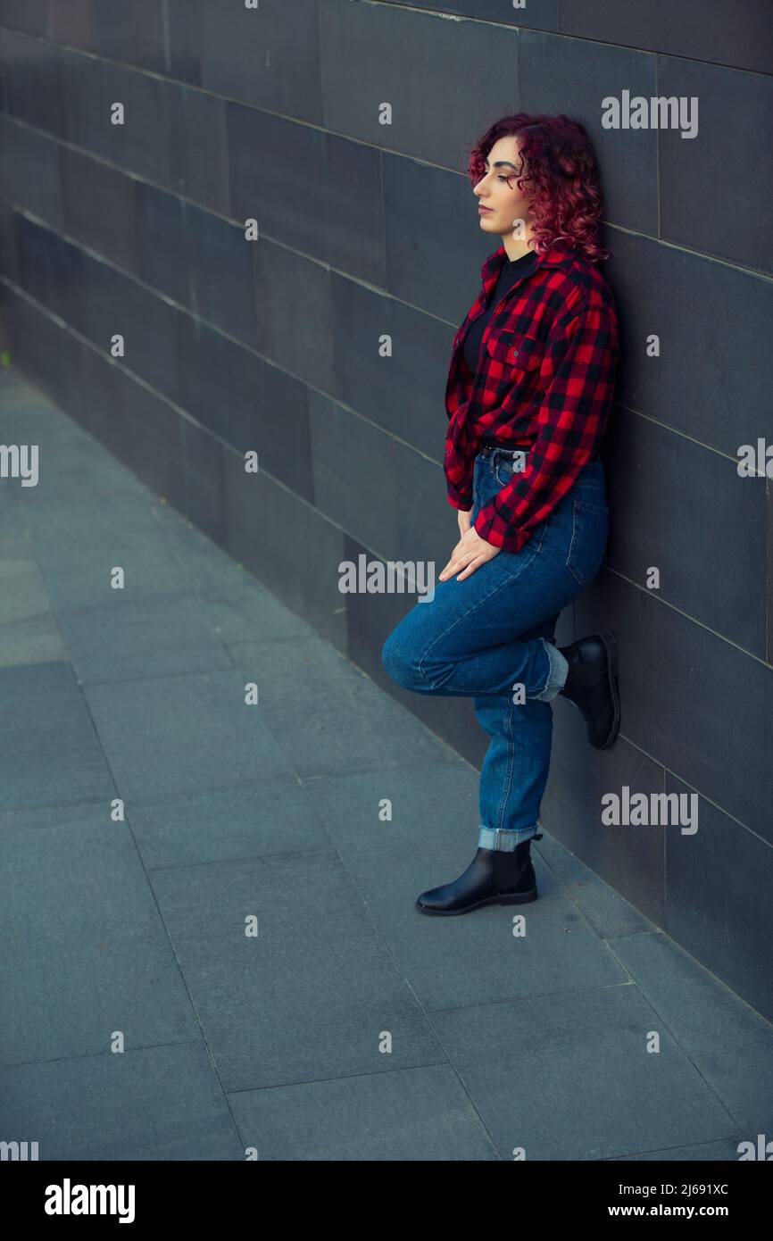 Woman leaning against the wall Stock Photo - Alamy