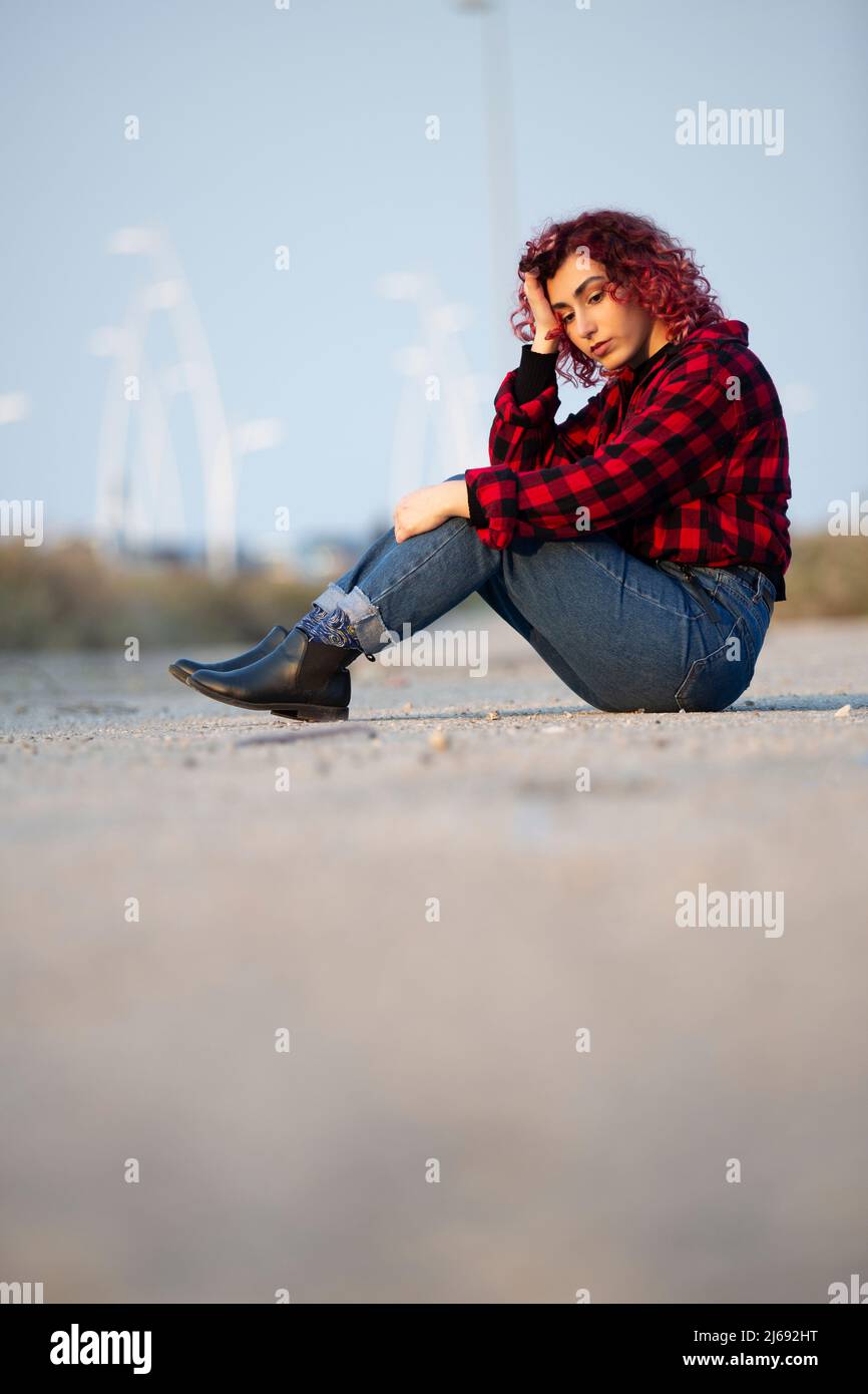 Woman sitting on the rosd head in hands Stock Photo - Alamy