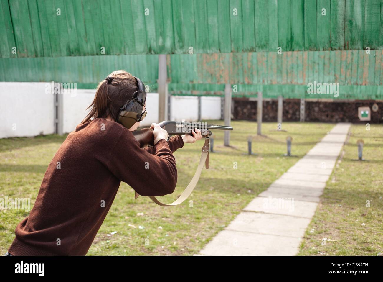 A young man shoots at metal flags, targets. Firearms pump-action ...