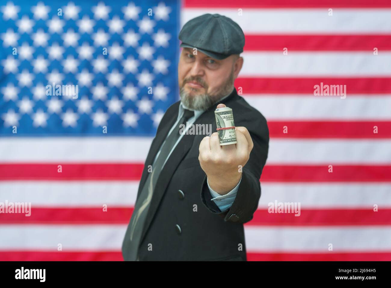A man shows the middle finger on which dollars are rolled up into a ...