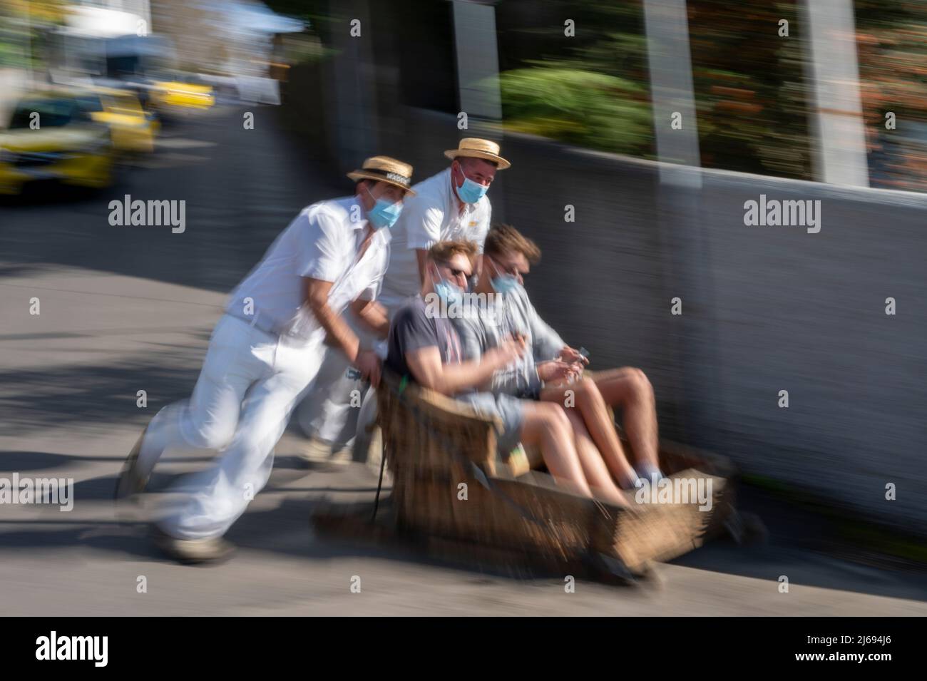 Tourists travelling down the toboggan basket ride, Madeira, Portugal ...