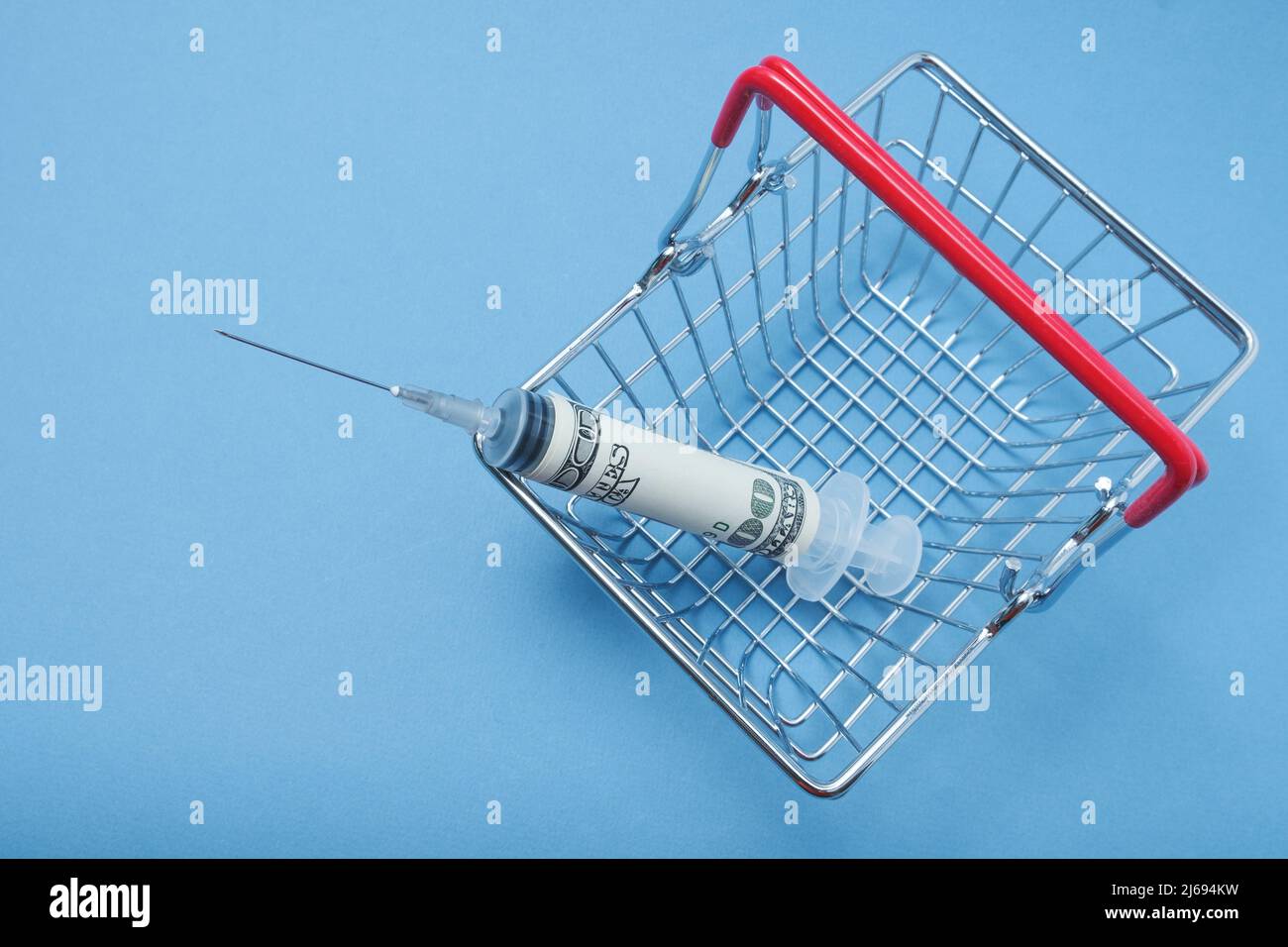 The syringe wrapped in a dollar is in the basket. Offering a financial ...