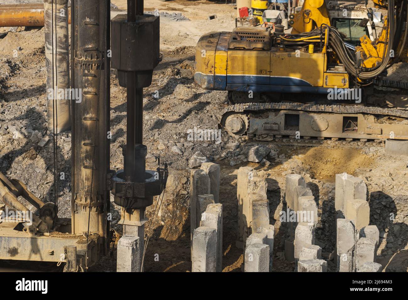 The pile driver drives the pile into the ground Stock Photo - Alamy