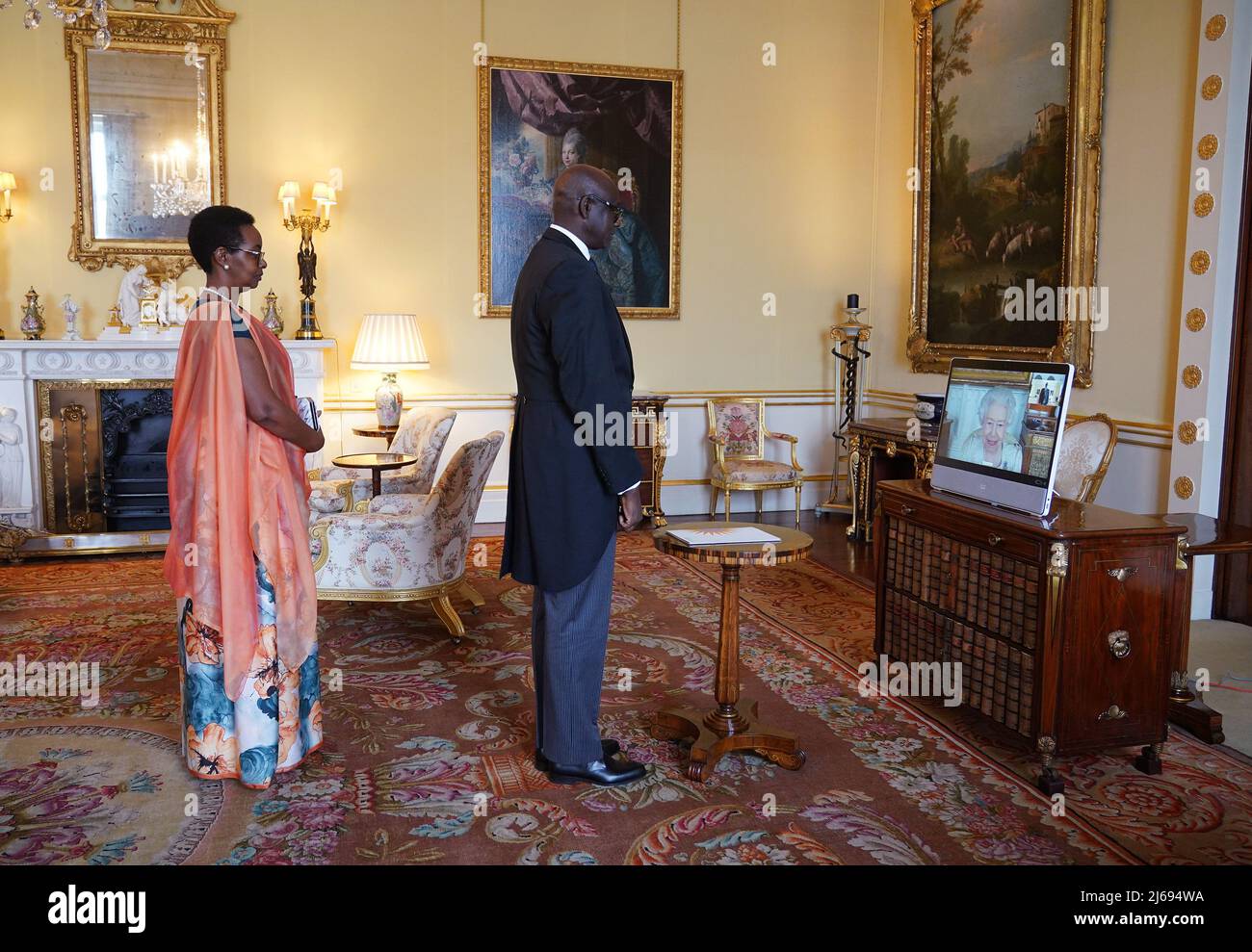Queen Elizabeth II, in residence at Windsor Castle, appears on a screen ...