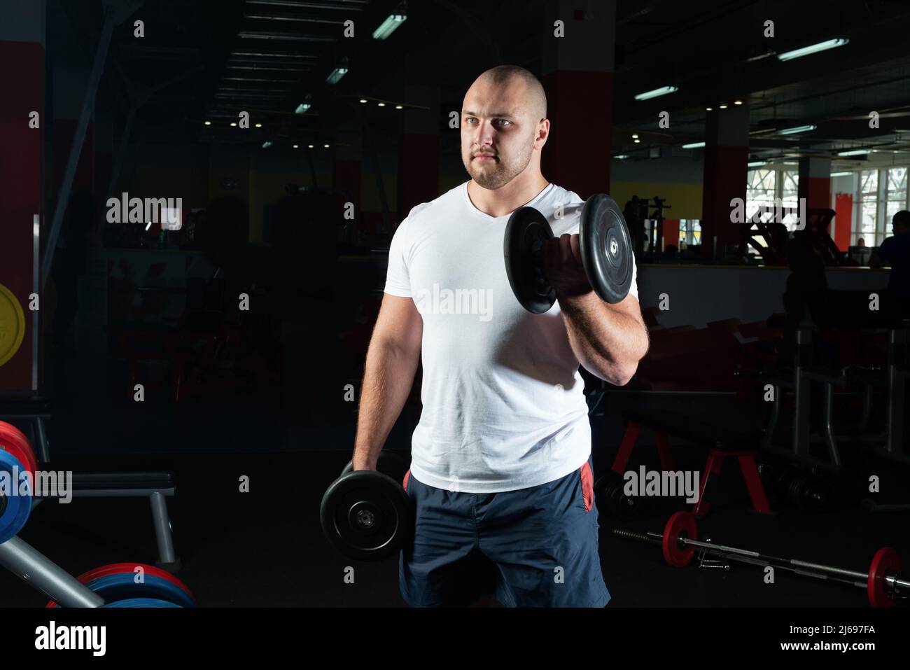 Male bodybuilder engaged with dumbbells in the gym Stock Photo - Alamy