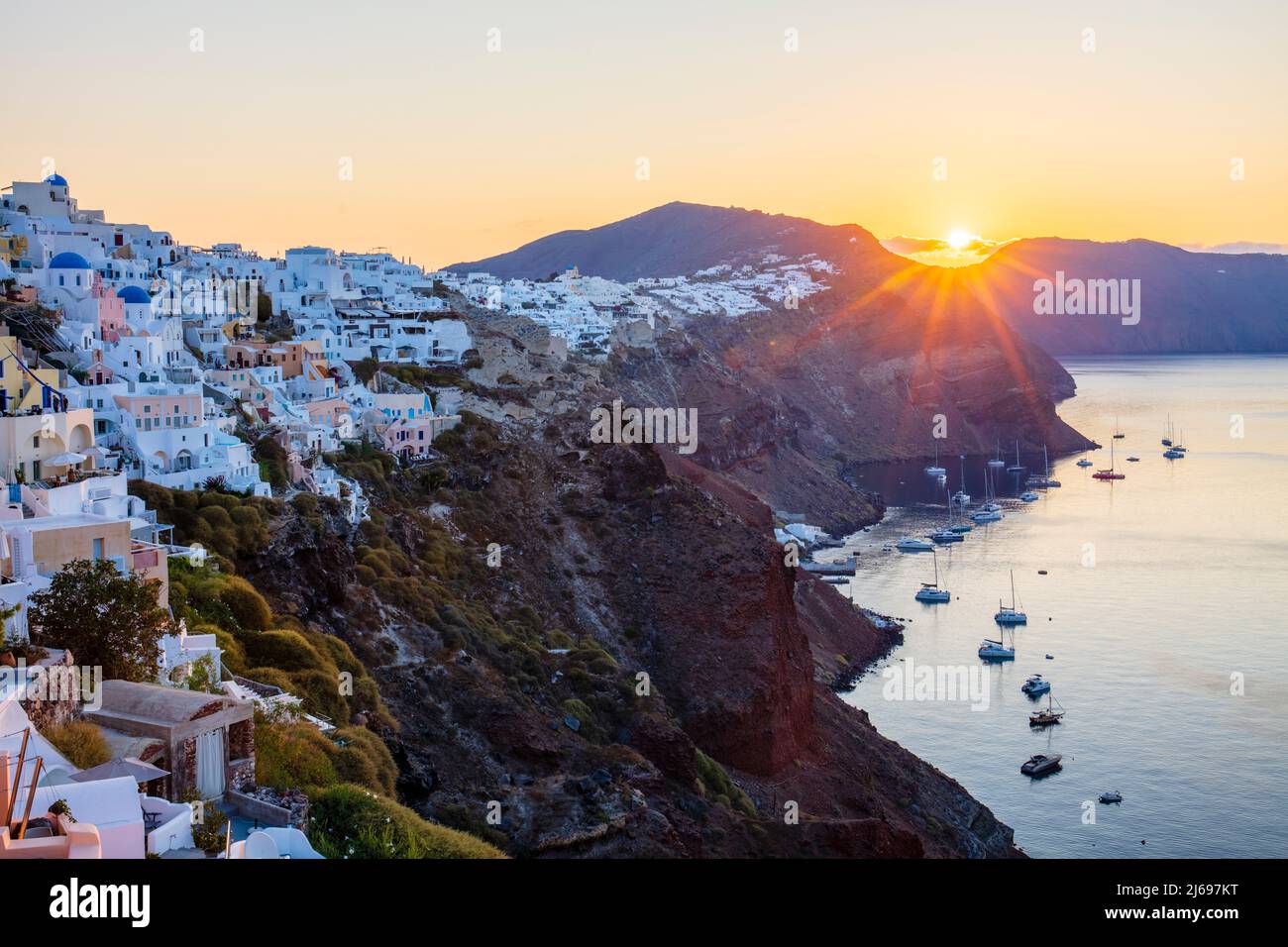 Sunrise over coast of Oia and typical white buildings, Santorini, Cyclades, Greek Islands ...