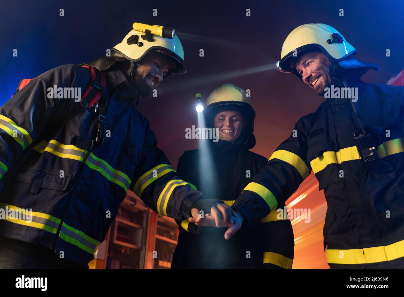 Happy firefighters men and woman after succesful action with fire truck ...