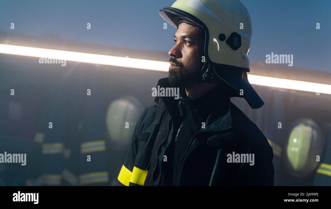 Young African-American firefighter in fire station at night Stock Photo ...