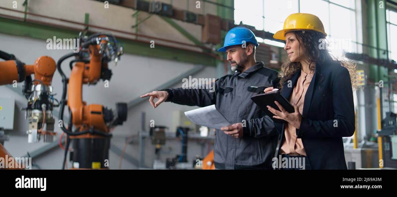 Female engineering manager and mechanic worker doing routine check up ...