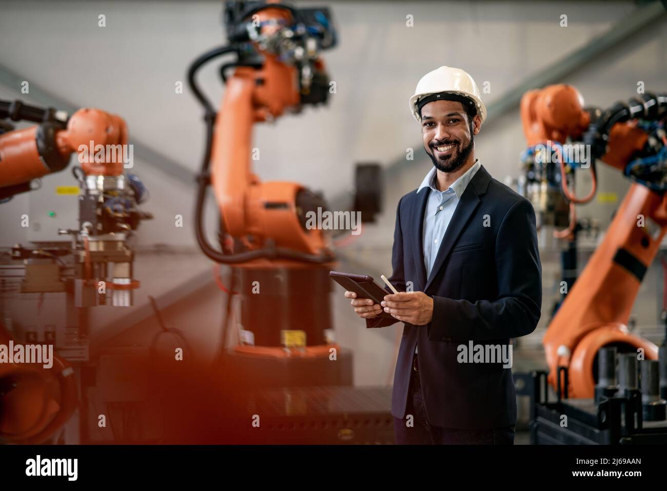 Automation engineer uses tablet for programming robotic arm in factory Stock Photo - Alamy