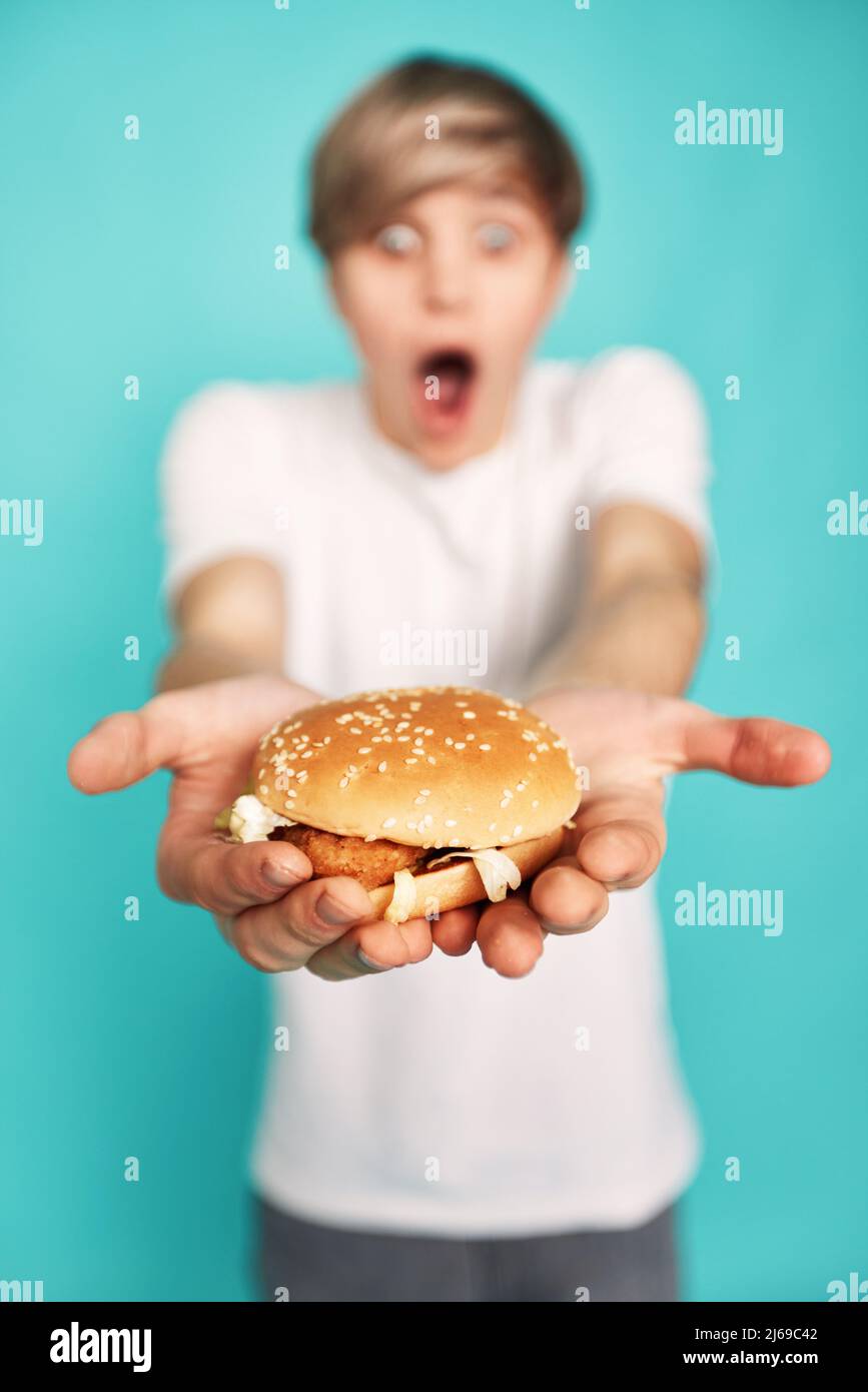 Very hungry young man holding tasty hamburger Stock Photo - Alamy