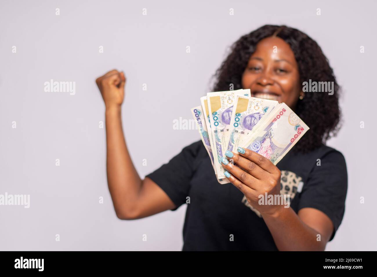excited african lady holding money rejoices Stock Photo - Alamy