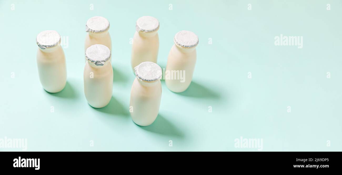 Small bottles with probiotics prebiotics dairy drink on blue background ...