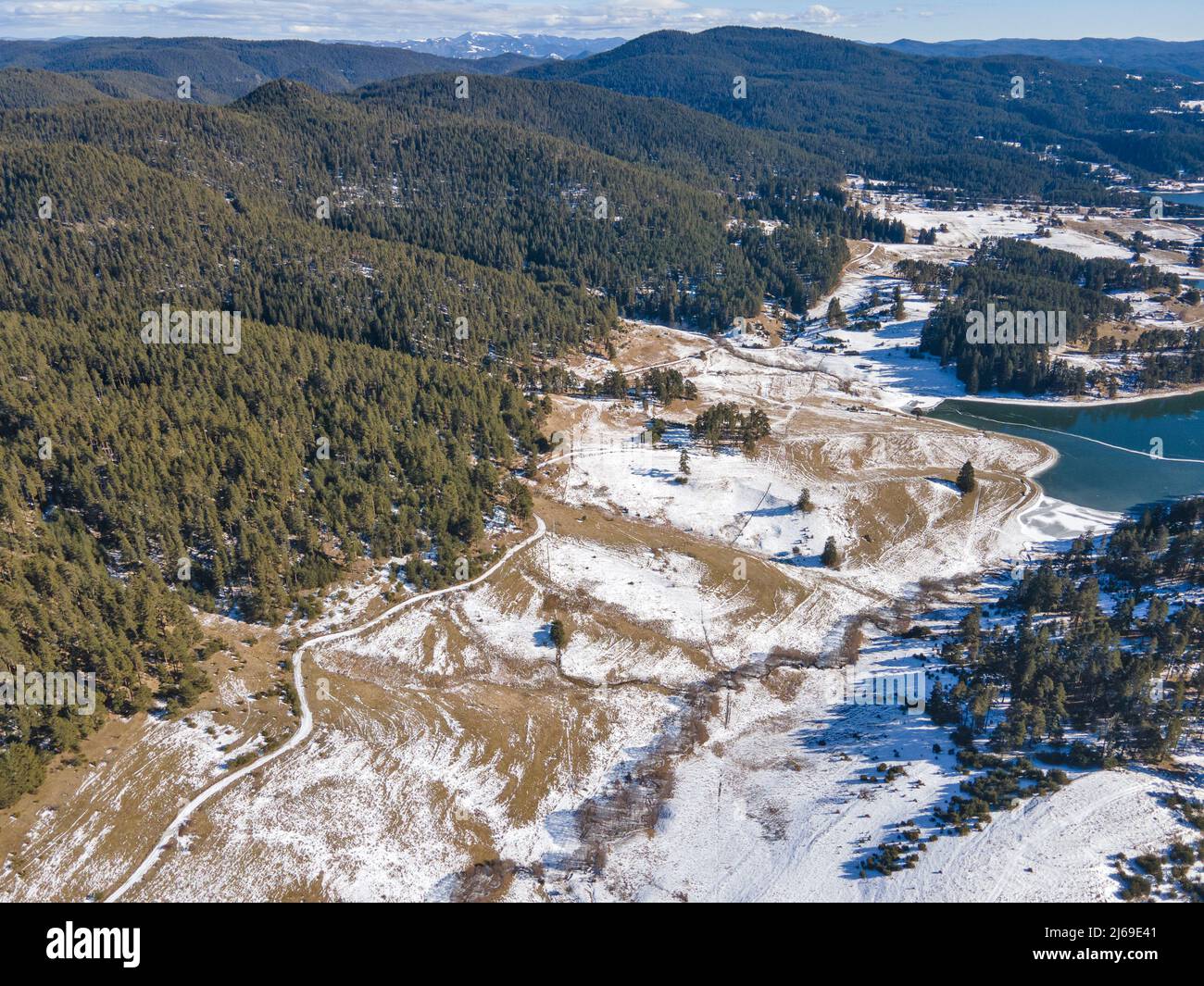 Aerial winter view of Dospat Reservoir covered with ice, Smolyan Region ...