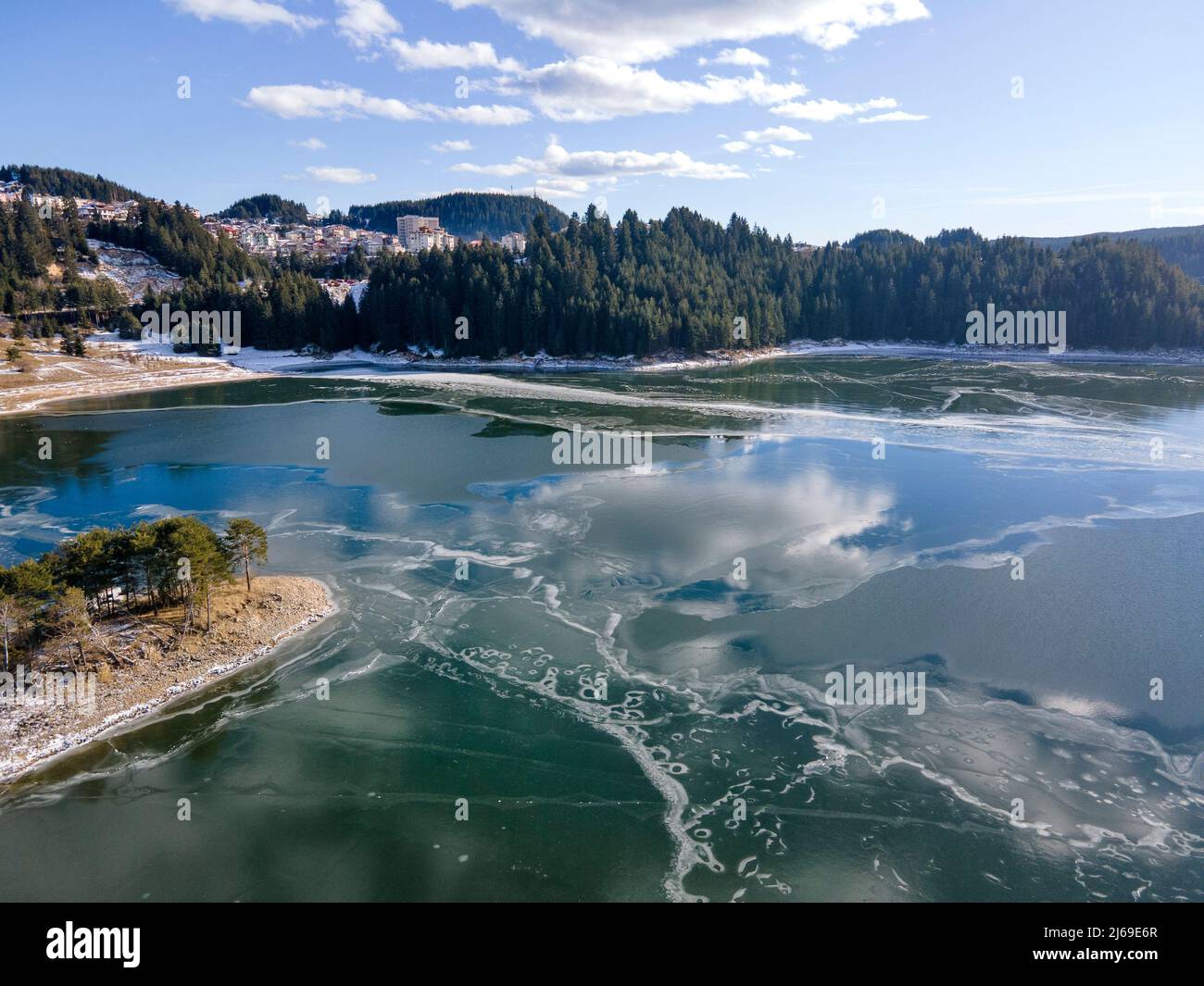 Aerial winter view of Dospat Reservoir covered with ice, Smolyan Region ...