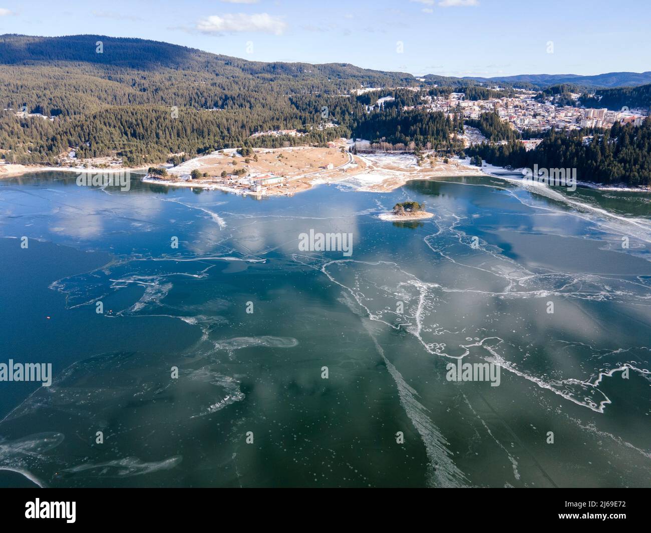 Aerial winter view of Dospat Reservoir covered with ice, Smolyan Region ...