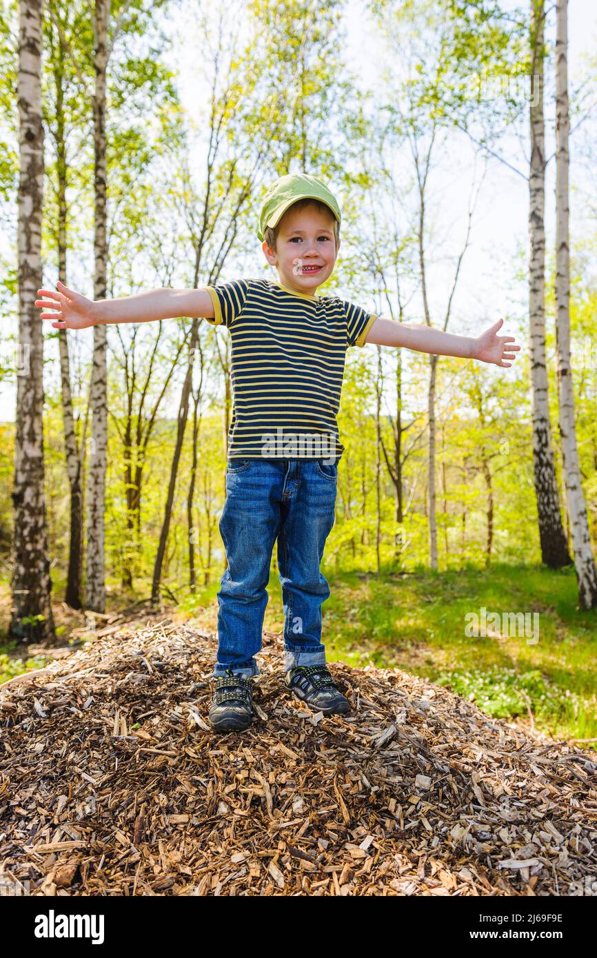 Happy little boy standing in front of spring forest Stock Photo - Alamy