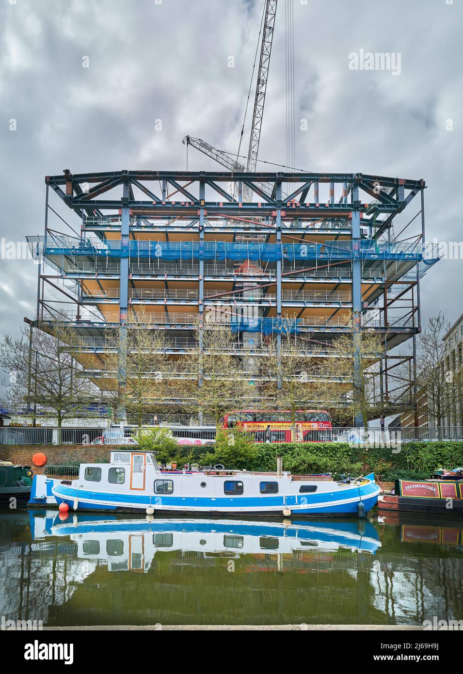 A canal boat parked on Regents canal in front of a building under ...
