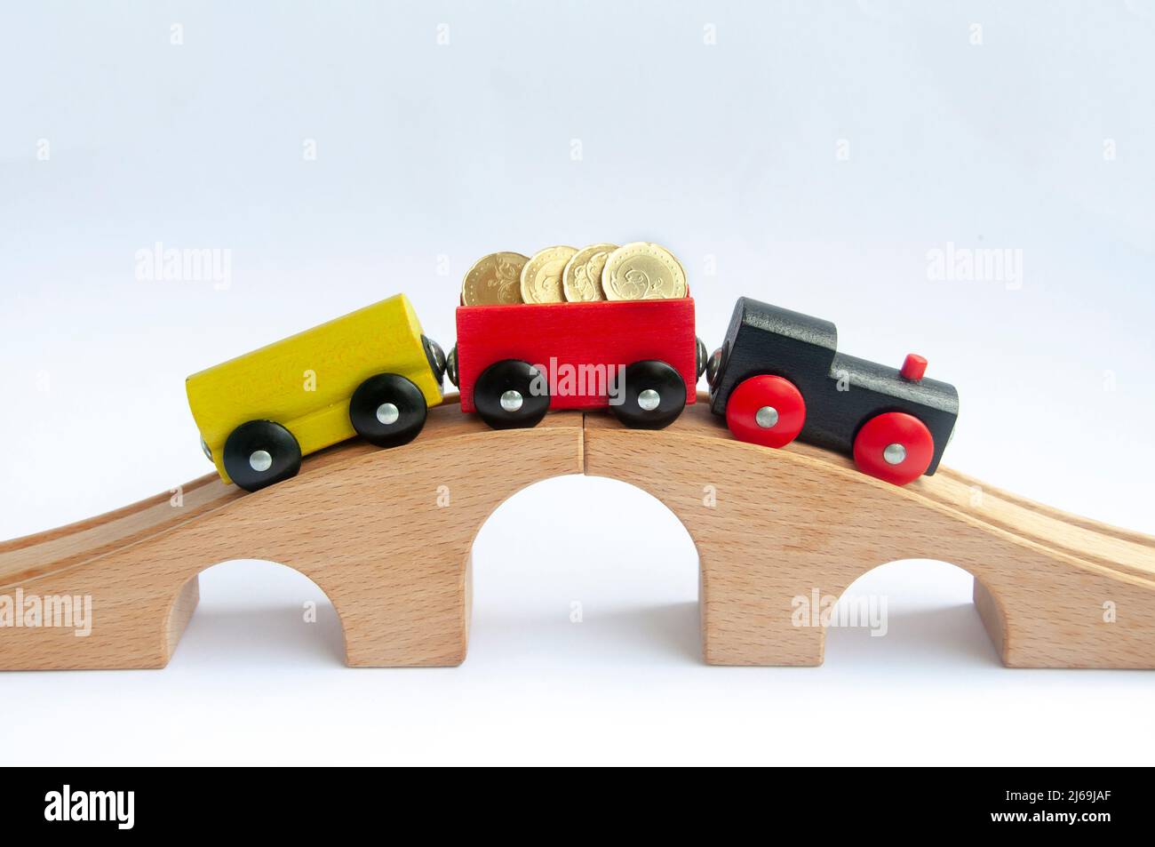 Wooden toy train with gold coins. Conceptual Stock Photo - Alamy
