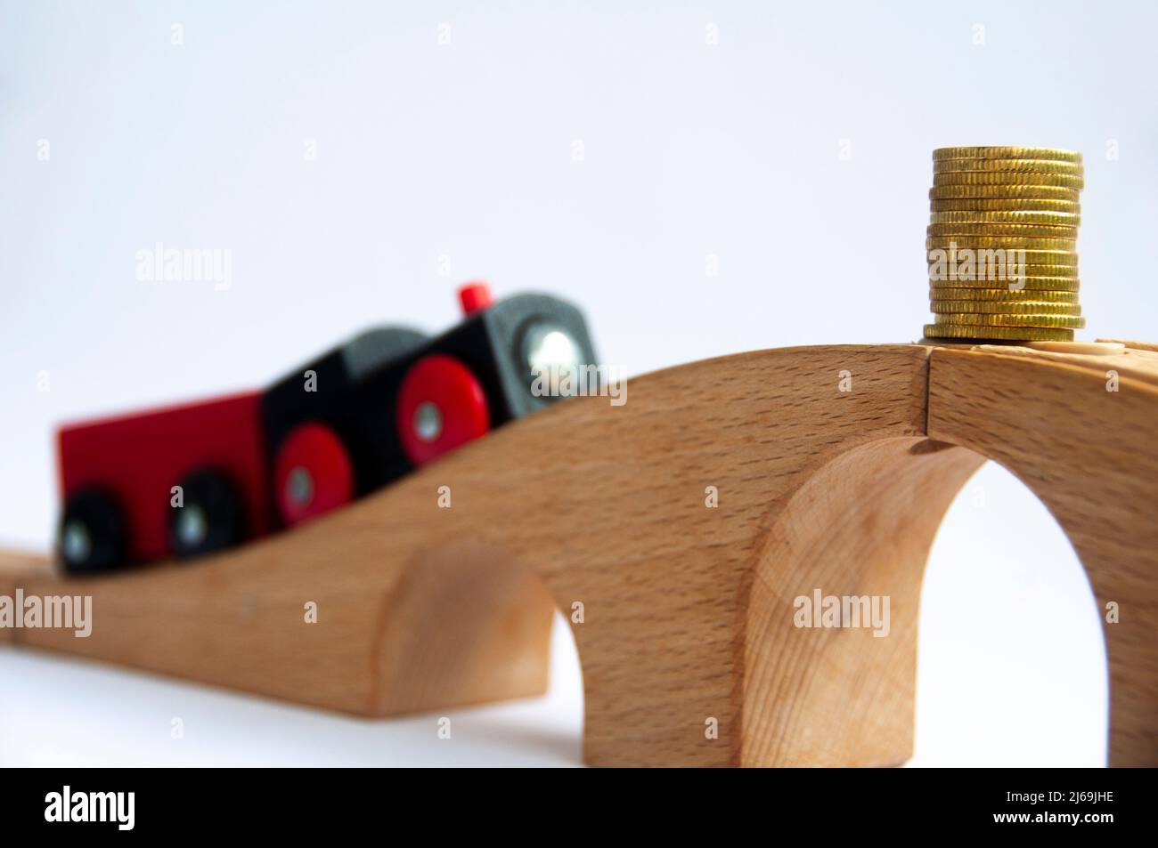 Wooden toy train heading to gold coins. Conceptual Stock Photo - Alamy