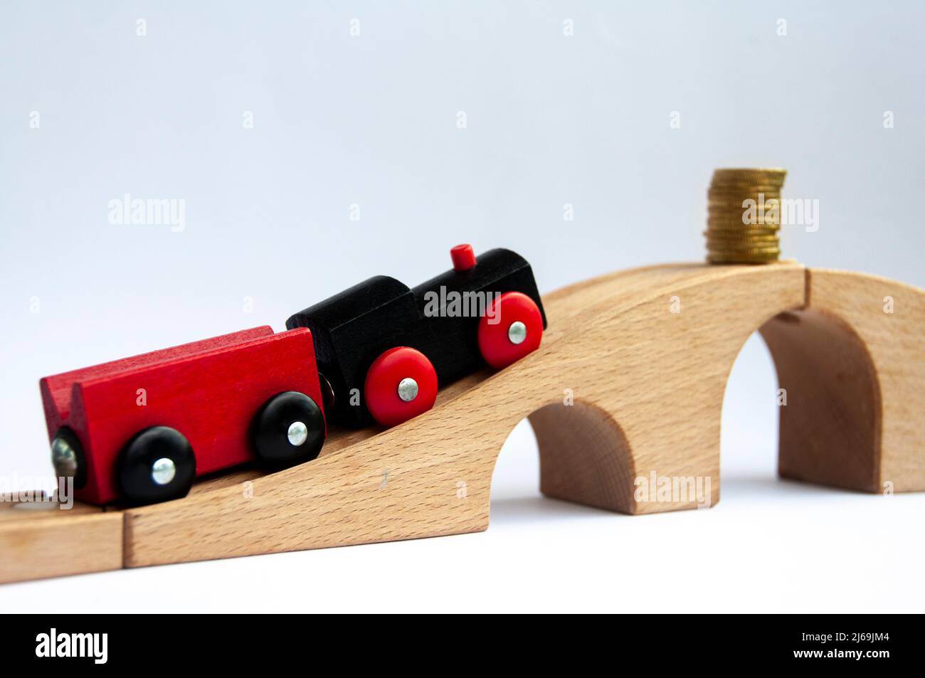 Wooden toy train heading to gold coins. Conceptual Stock Photo - Alamy