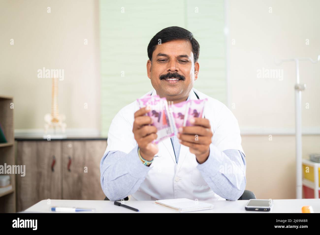 happy smiling doctor couting money at hospital - concept of earning ...
