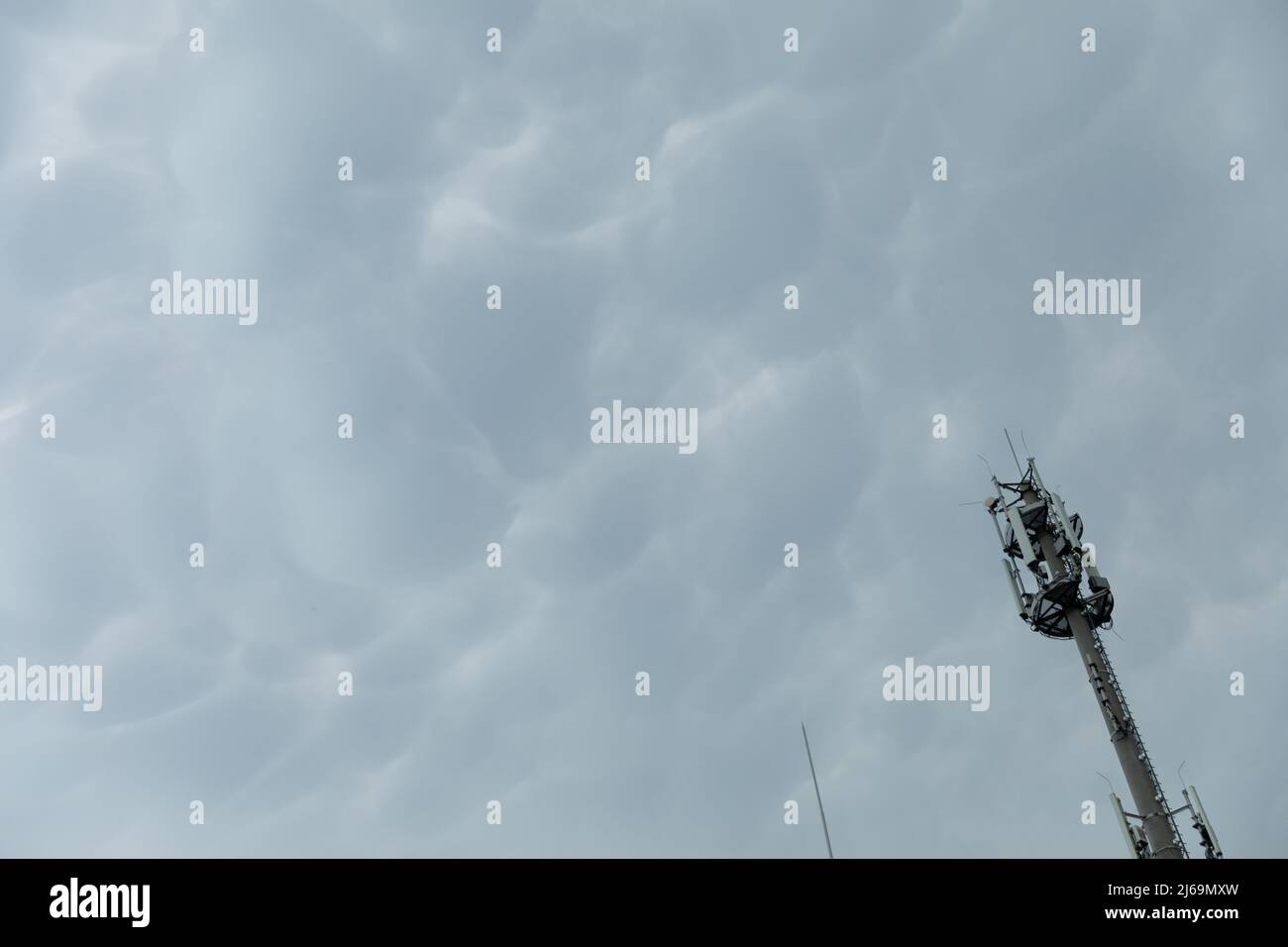 Cell phone transmission tower against a background of storm clouds ...