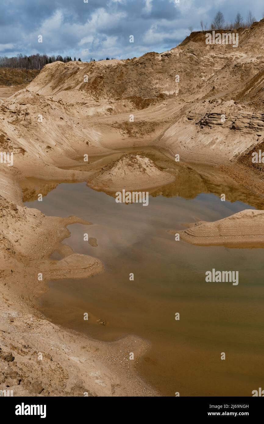 Sand dunes on all sides and an artificial pond in the middle. A small ...