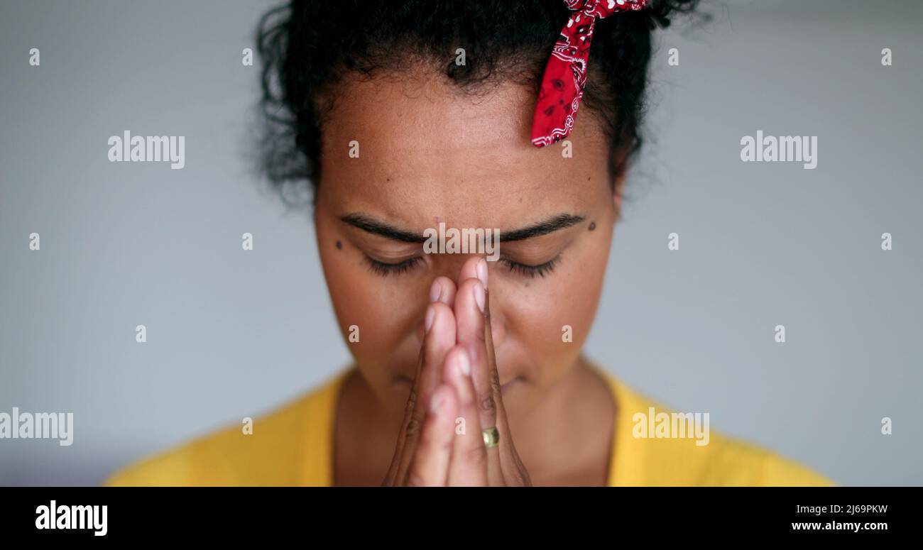 Young black woman praying in contemplation Stock Photo - Alamy