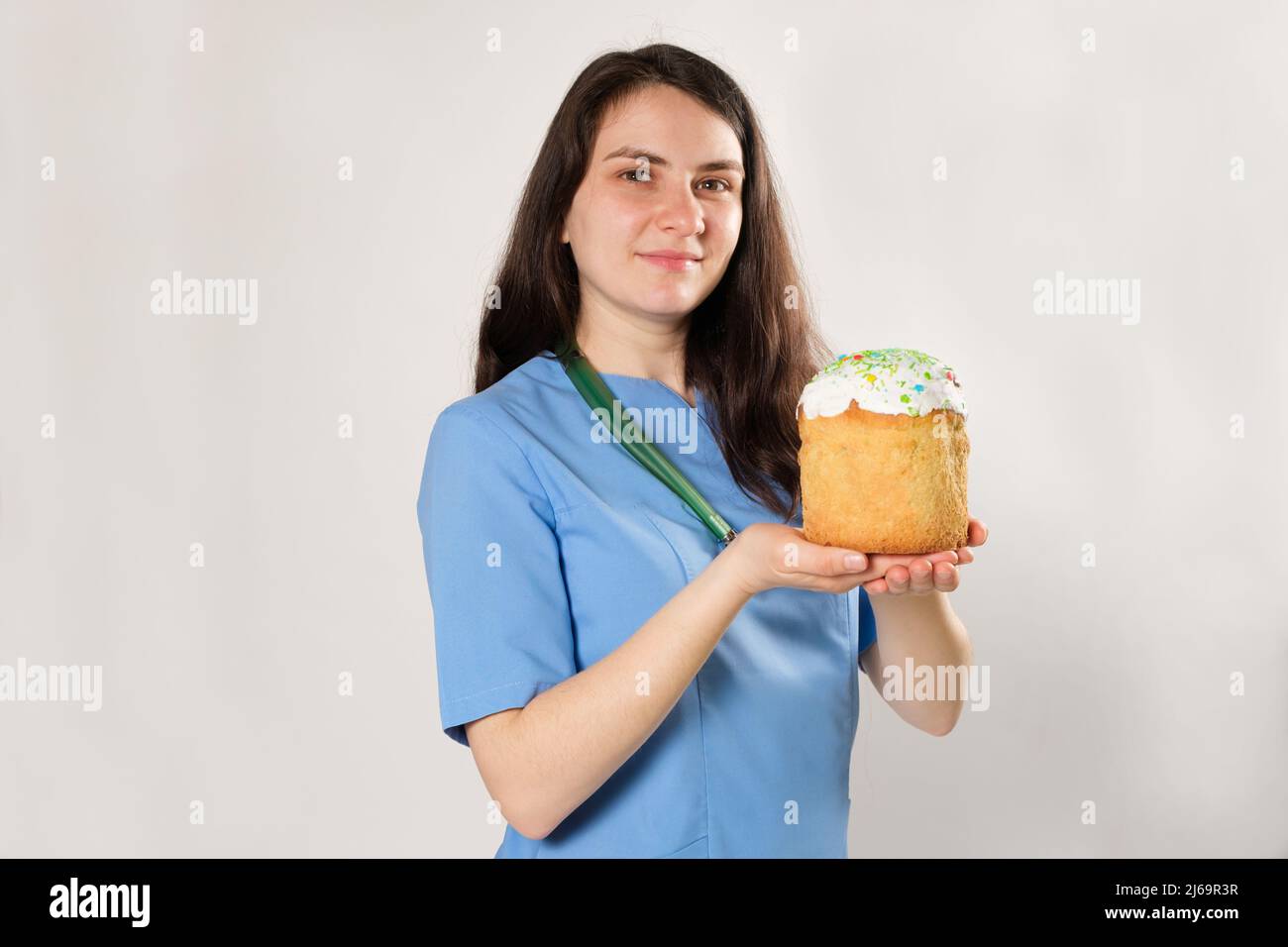The doctor holds an Easter cake and smiles, a place for text. Medical ...