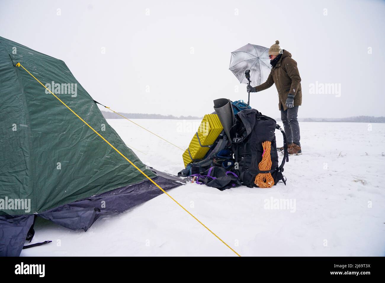 The guy sets the off-camera flash for shooting outdoors in winter Stock ...