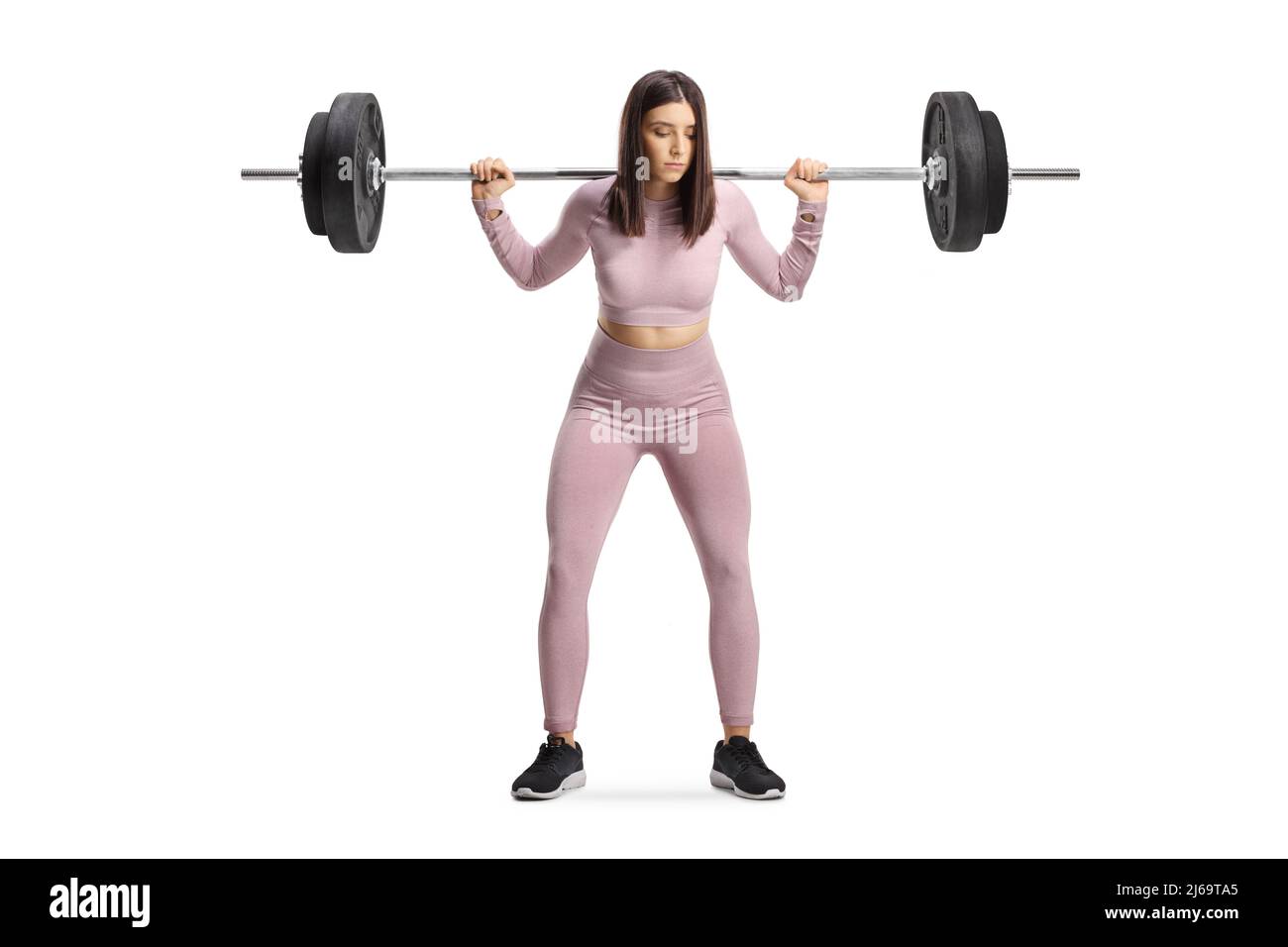 Sporty female standing and lifting heavy weights on shoulders isolated ...