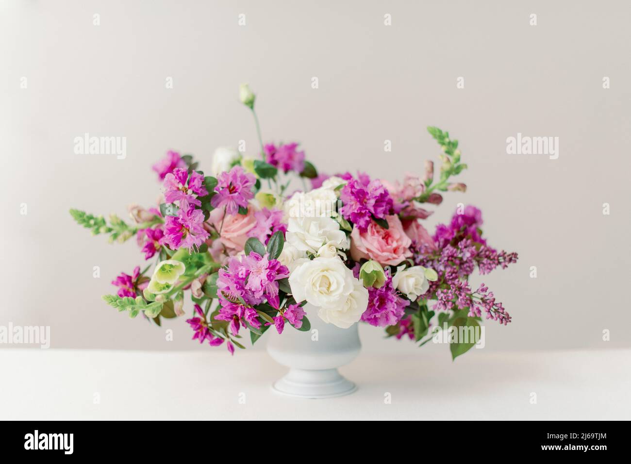 spring floral centerpiece with purple lilacs and pink roses inside ...