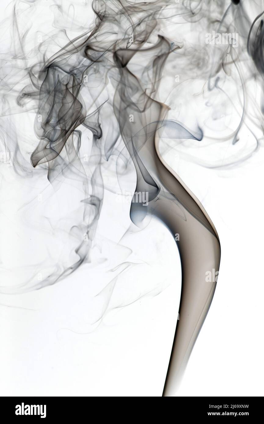 Puffs and curls of dark smoke on a white background rising from a ...