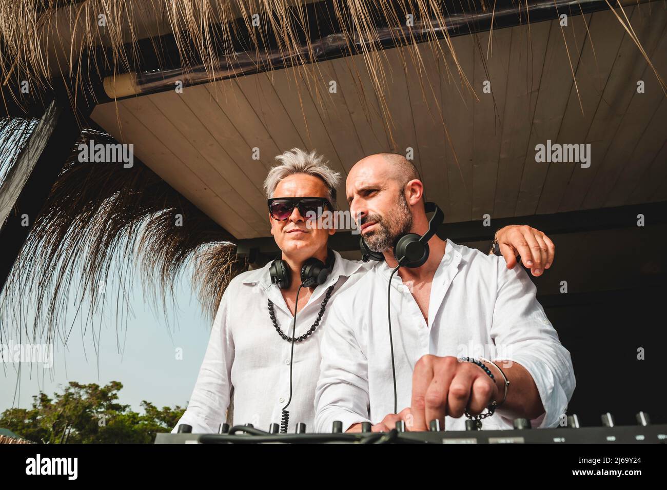 Disc jockeys playing music for tourist people at club party outdoors on ...