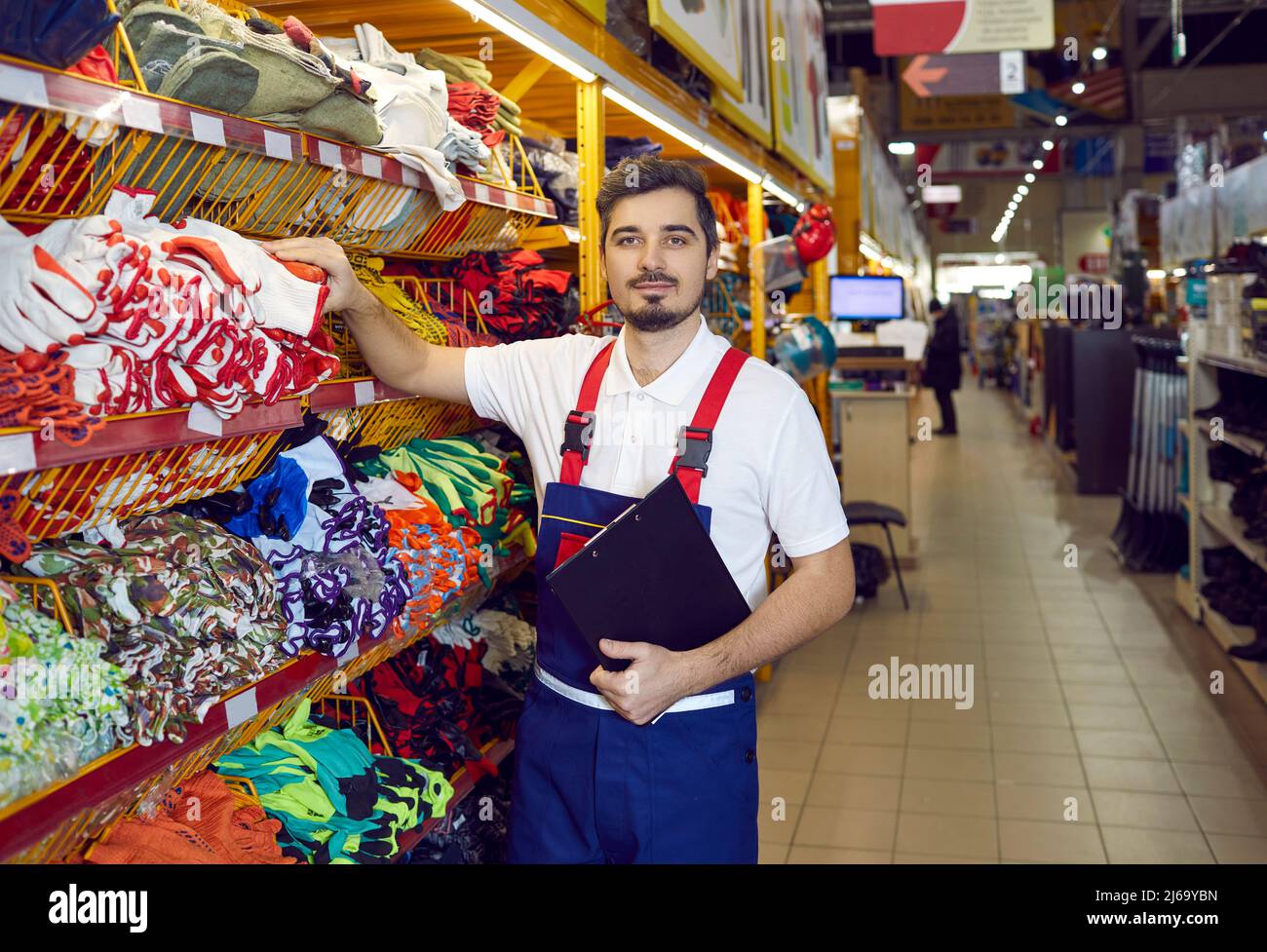 Male worker in hardware store makes inventory standing near showcase ...