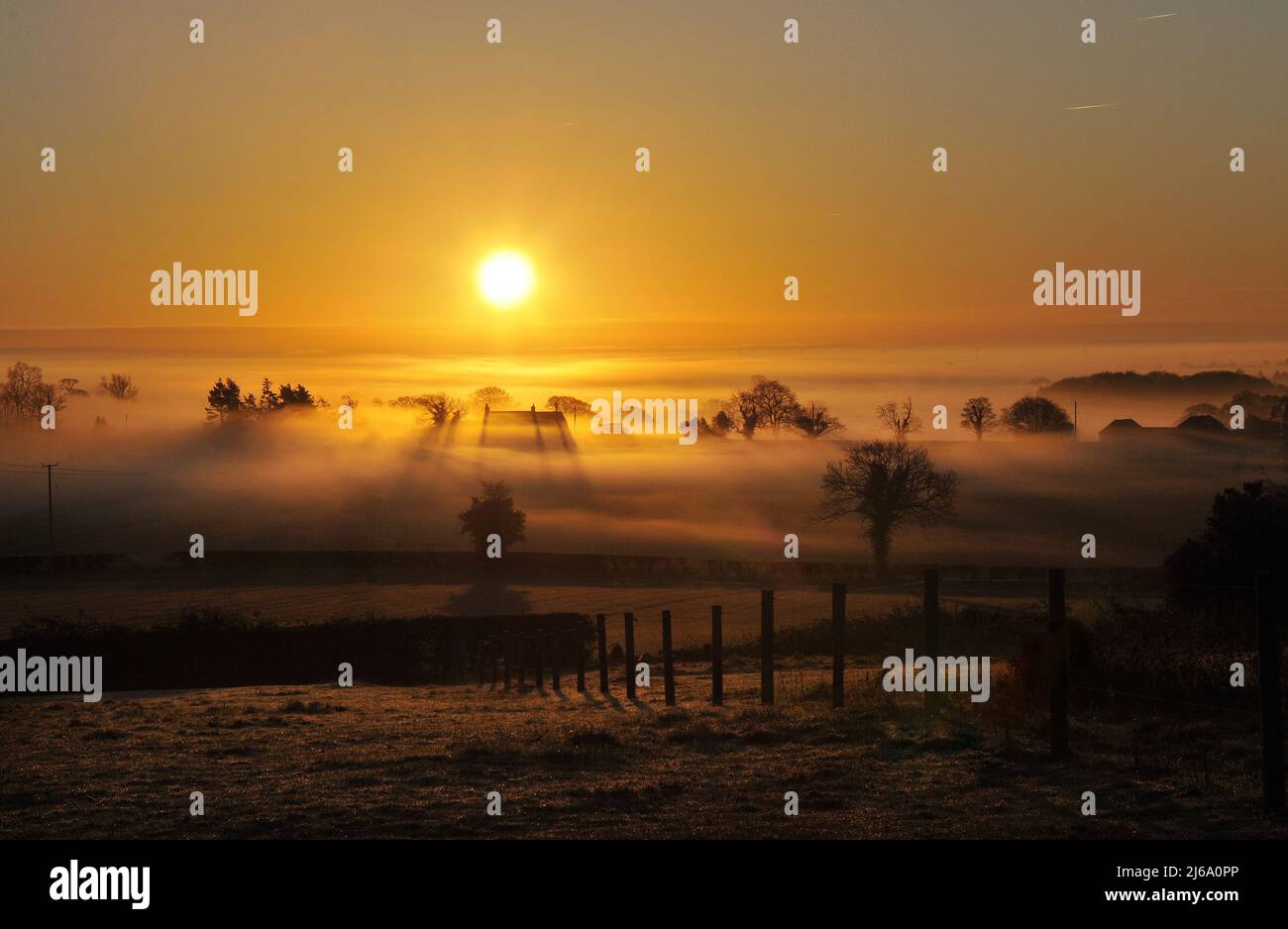 Sunrise over a farm house in the Vale of York at Crayke North yorkshire ...