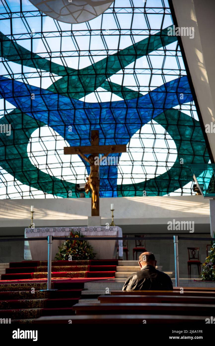 man praying inside the metropolitan cathedral of Brasilia. stained ...