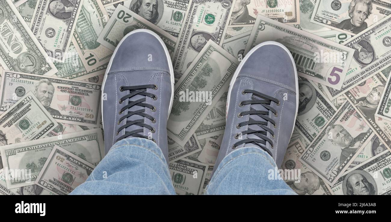 The money lies on the street. A person stands on US Dollar banknotes ...