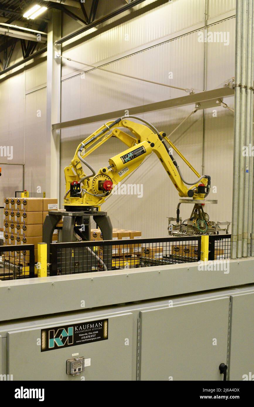 Robotic machine stacking pallet of cranberry juice boxes in the modern ...