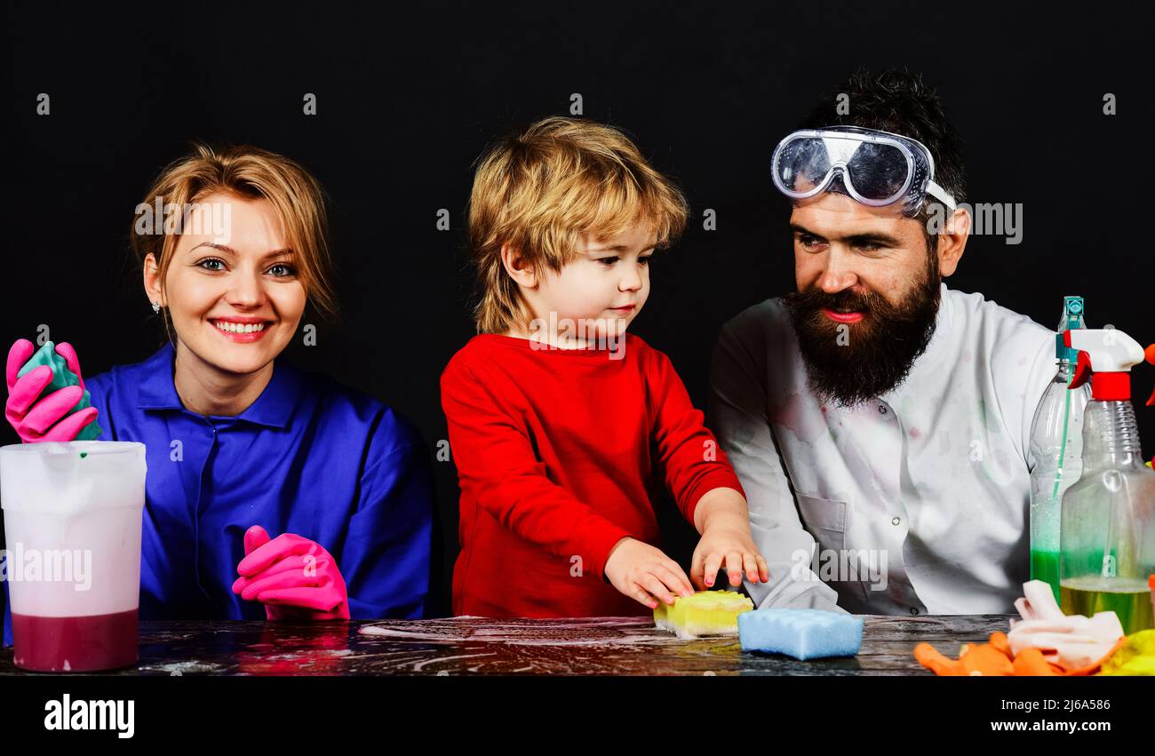 Mother and father teach little son cleans in house. Family clean ...