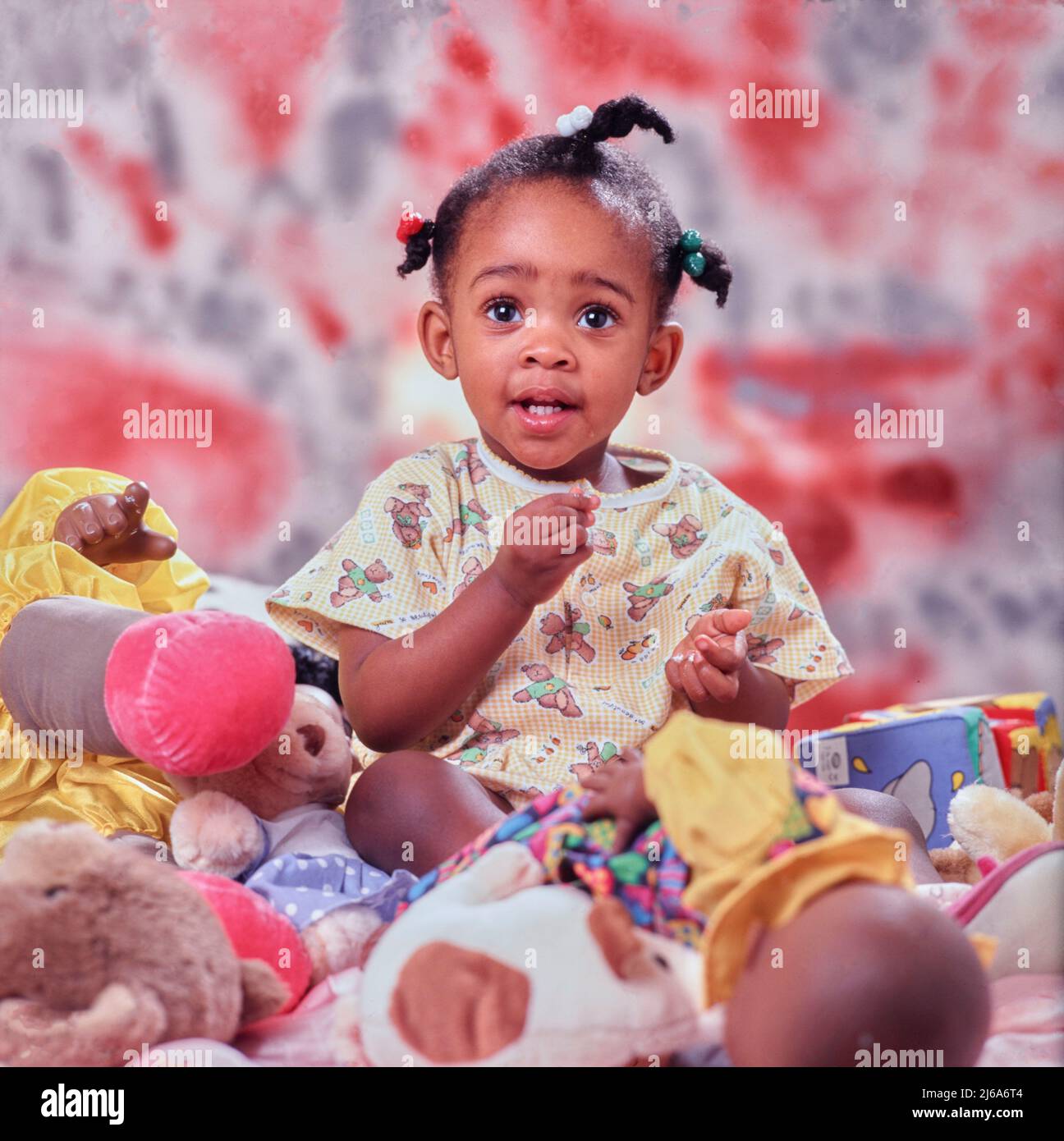 British Afro-Caribbean child (baby) with toys making funny face Stock ...