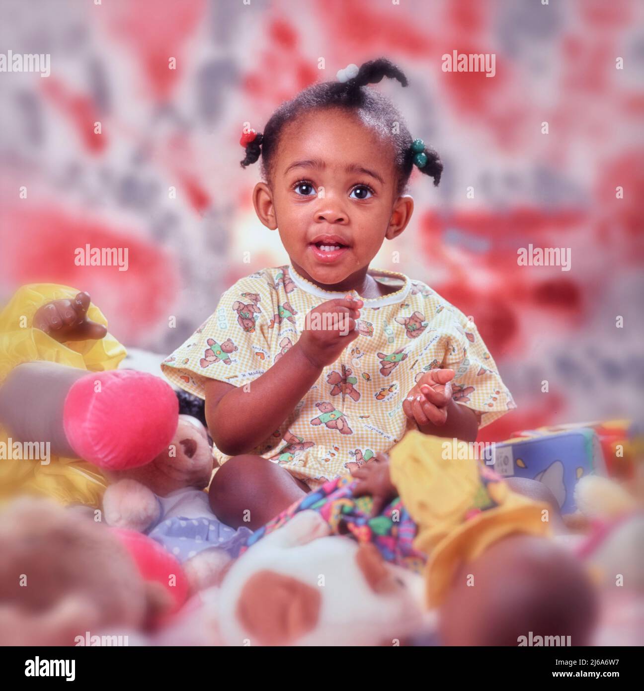 Happy smiling British Afro-Caribbean child (tot) with toys/dolly Stock Photo - Alamy
