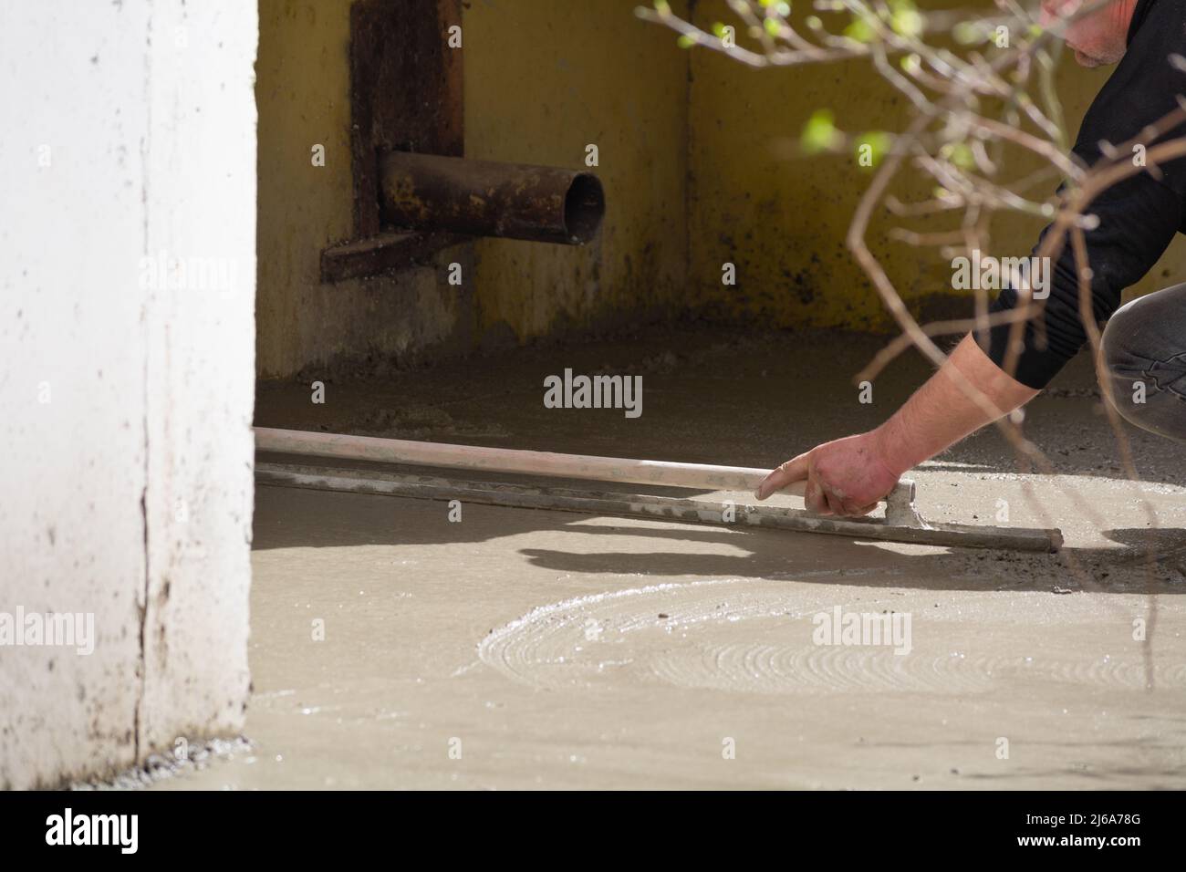 Construction worker aligns concrete screed. Construction, Foundation ...