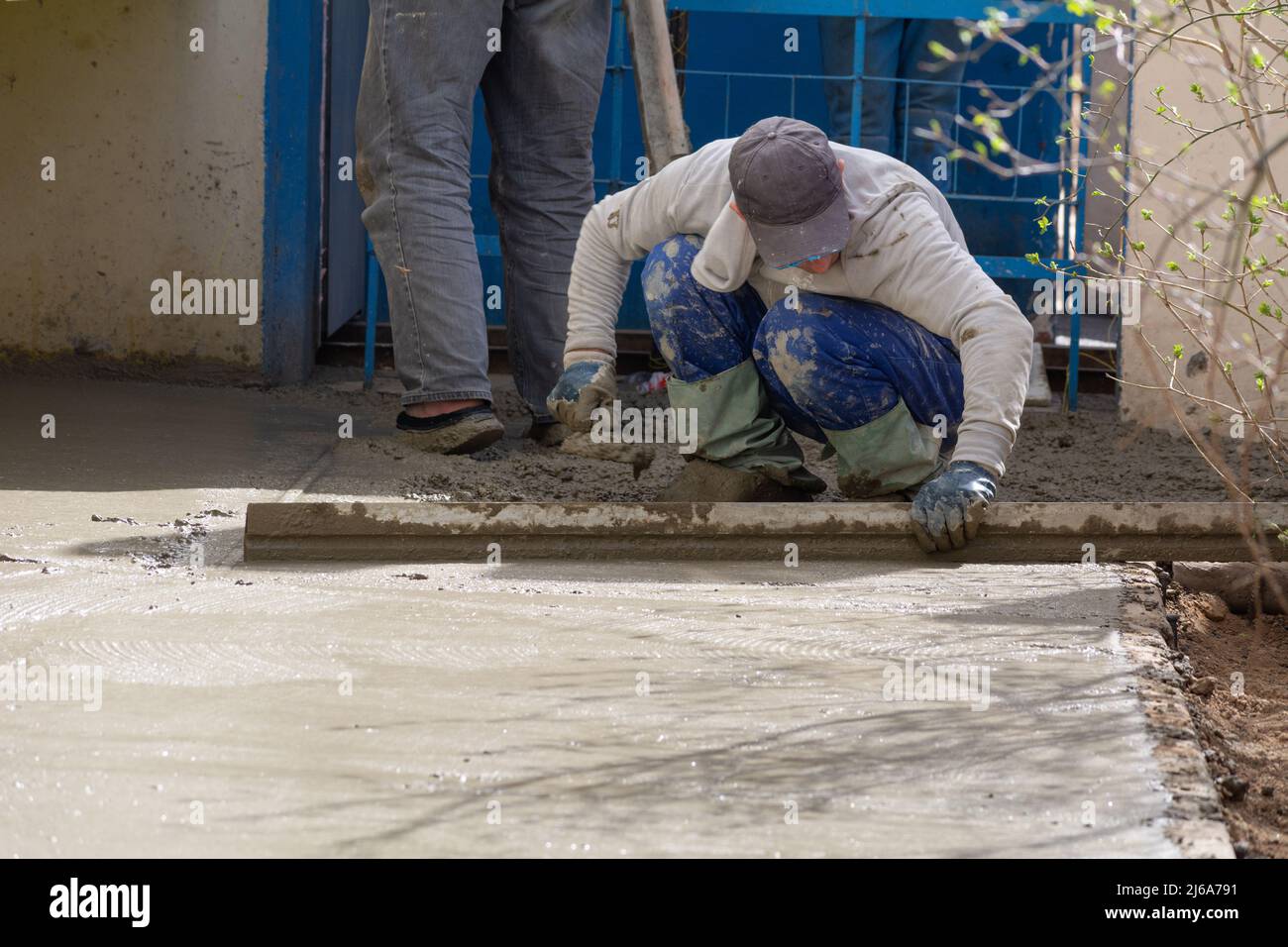 Construction workers aligns concrete screed. Construction, Foundation ...