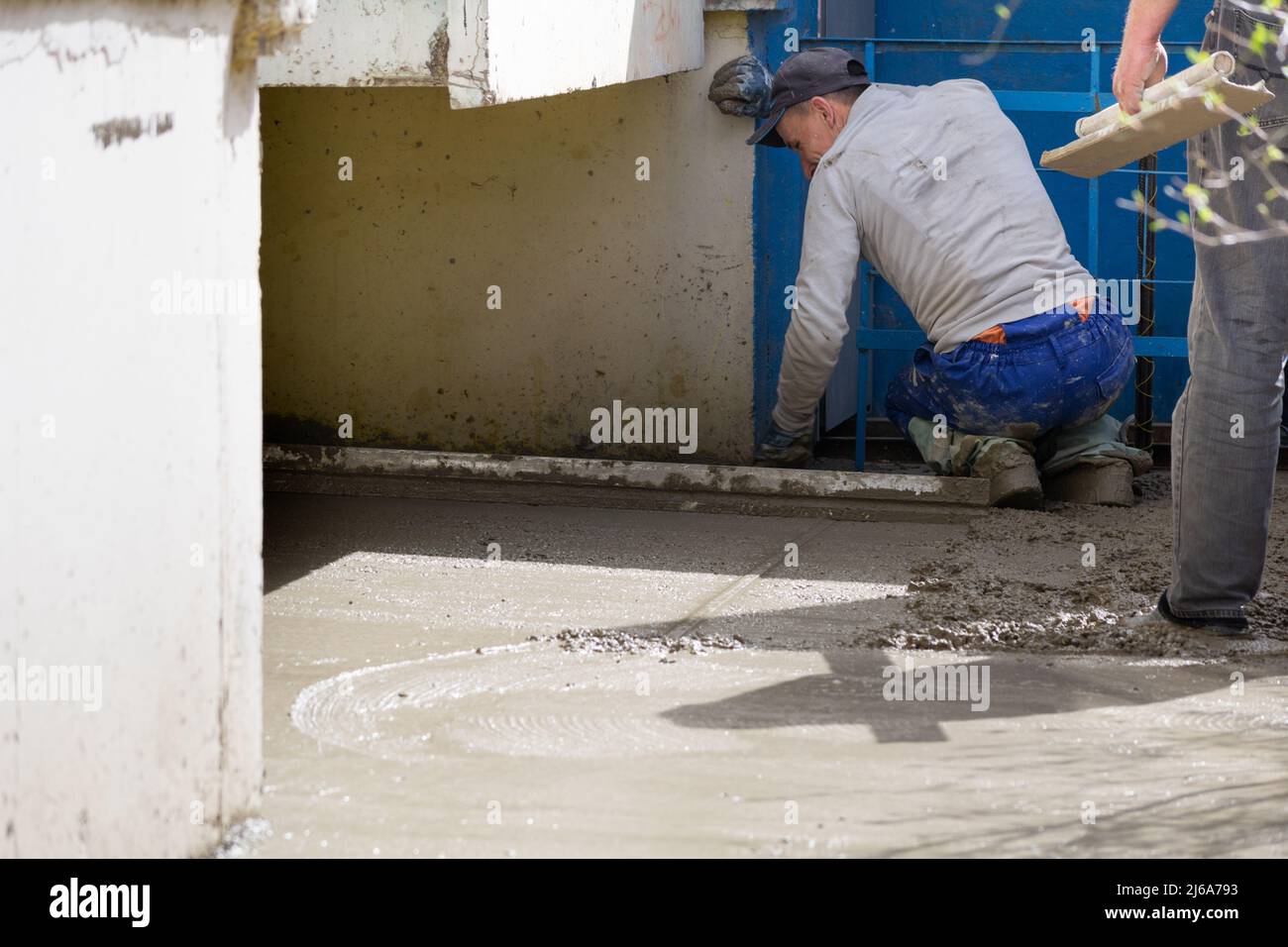 Construction workers aligns concrete screed. Construction, Foundation ...
