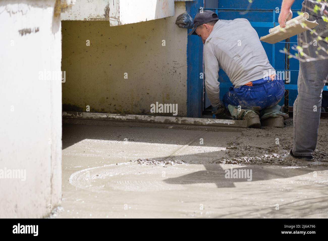 Construction workers aligns concrete screed. Construction, Foundation ...
