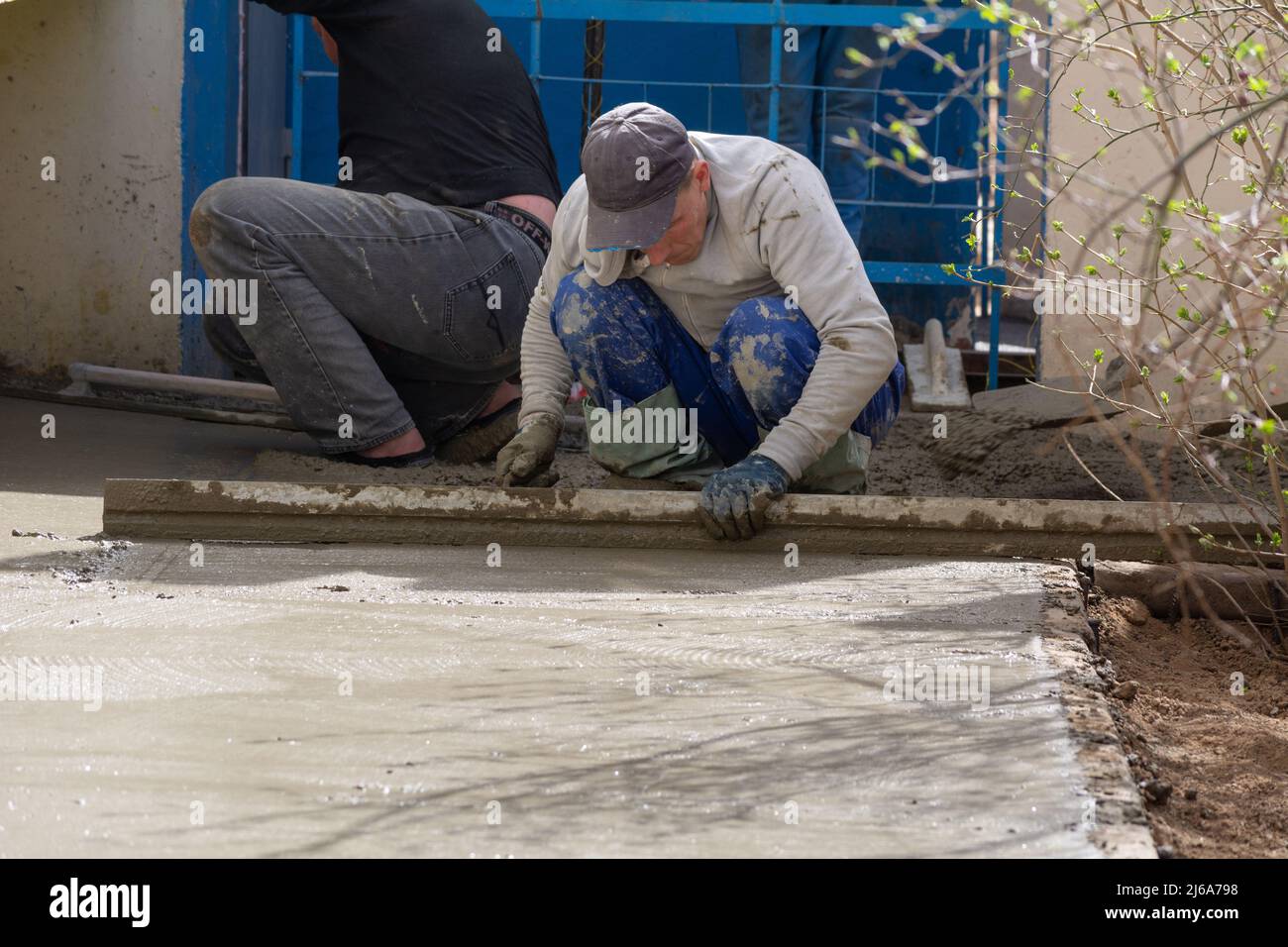 Construction workers aligns concrete screed. Construction, Foundation ...
