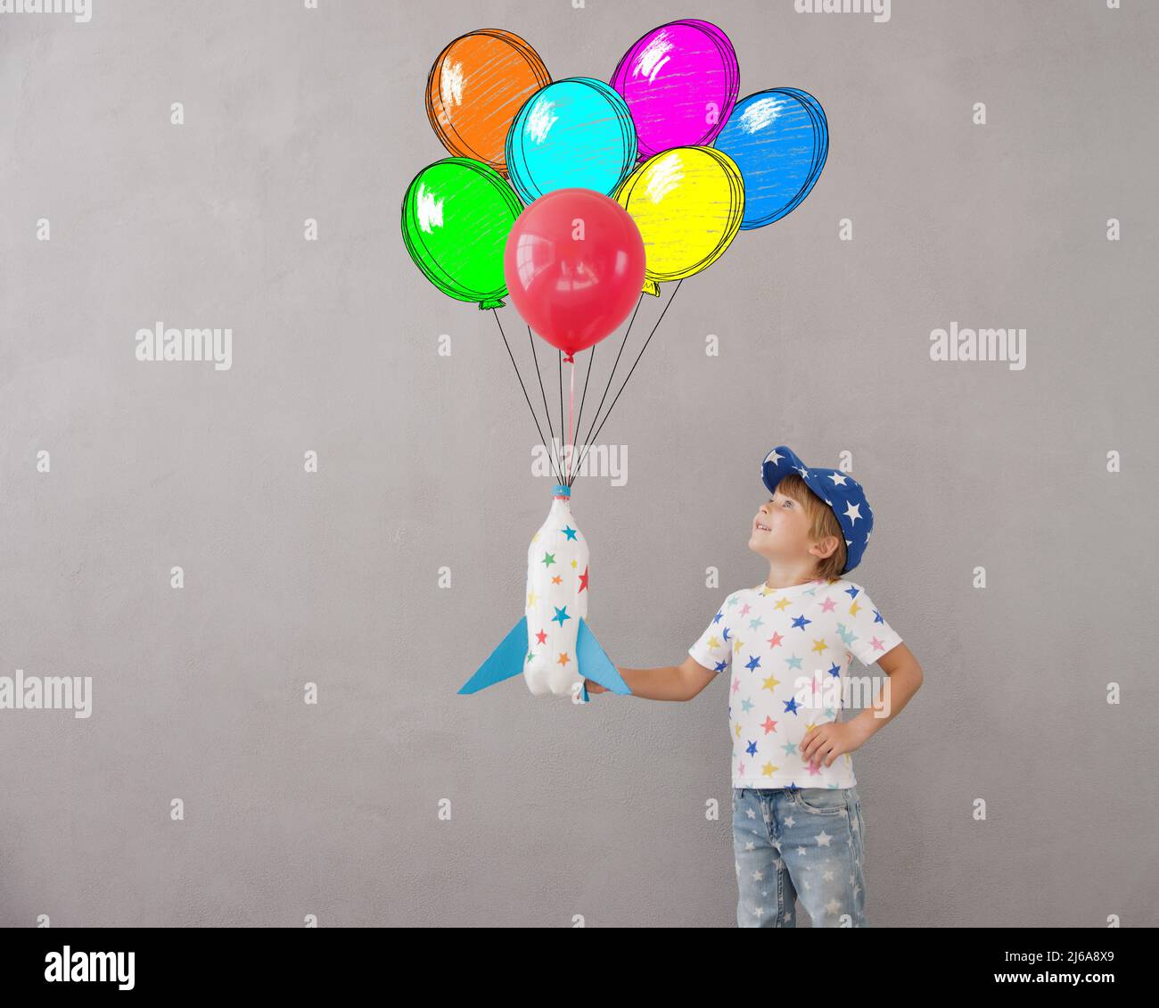 Happy child playing with toy rocket at home. Kid pretend to be ...